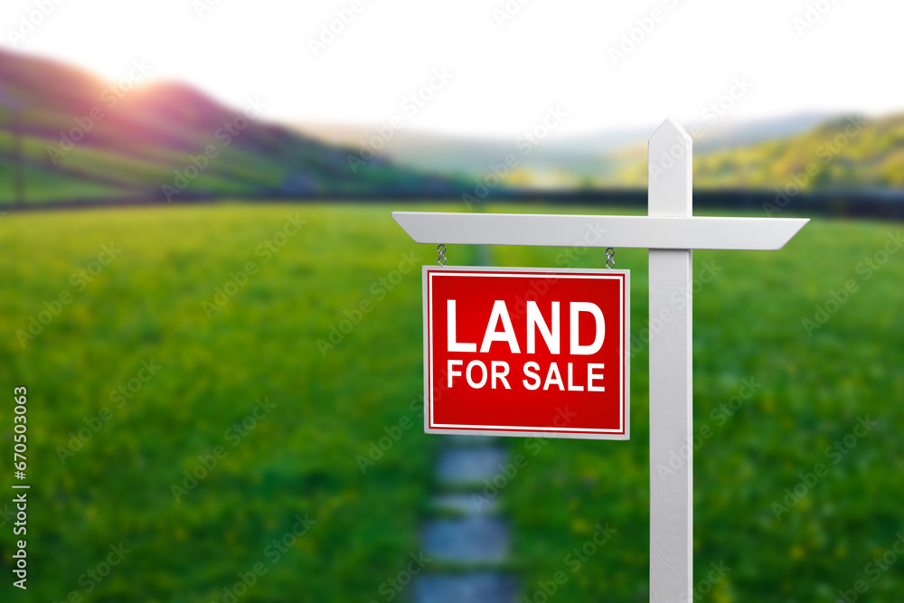 Land for sale sign in green grass field for housing development and ...