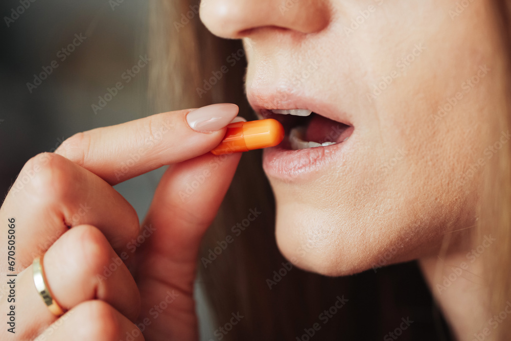 Orange pill in fingers. Woman holding drug. Narcotics background. Young ...