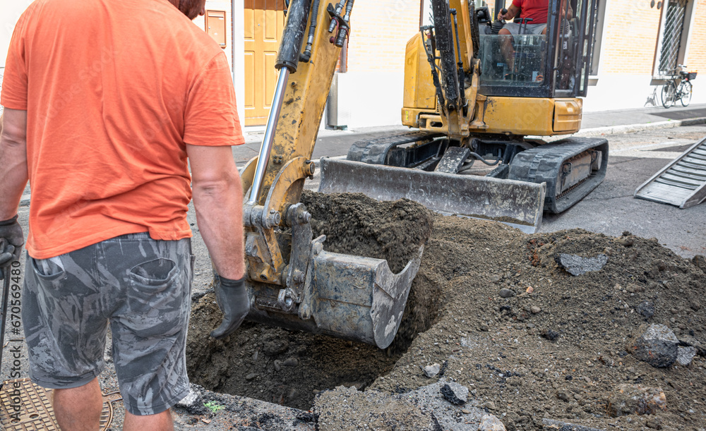 Operator supervising excavator while digging in Construction Area Stock ...
