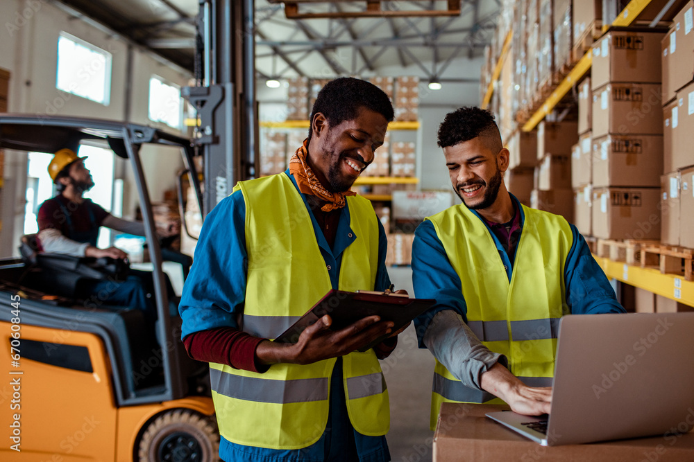 Warehouse Colleagues Reviewing Data on Laptop and Clipboard Stock Photo ...