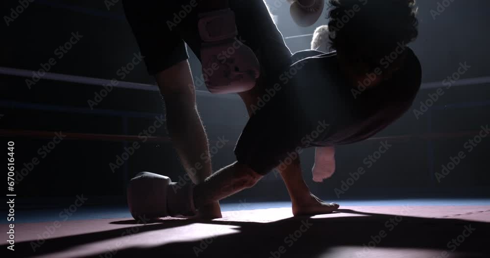 Dramatic fighting takedown in speed-ramp slow motion inside boxing ring ...