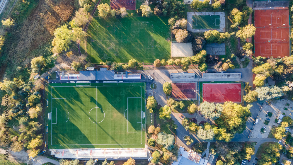Aerial top down view above the people playing football on a pitch among ...