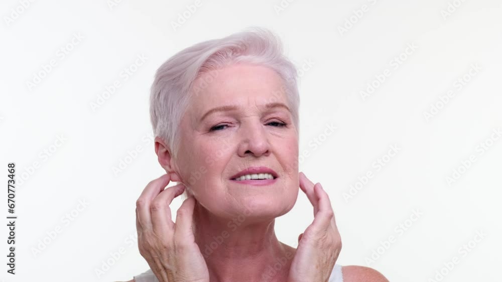 Composed Old woman gently caresses face with a serene expression. Her ...