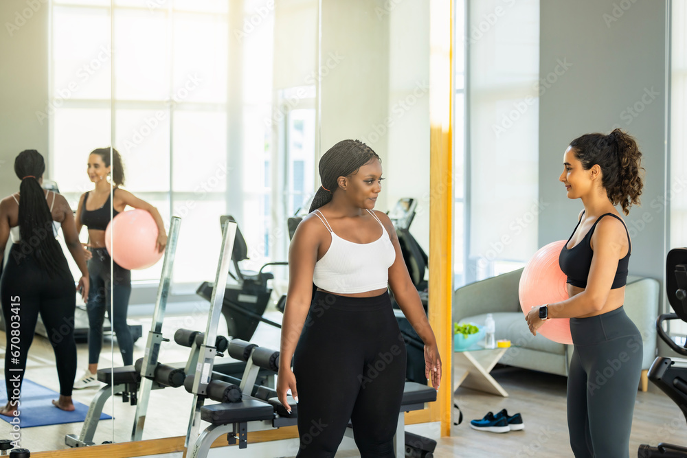 Plus size model woman standing in the modern gym and discussing ...