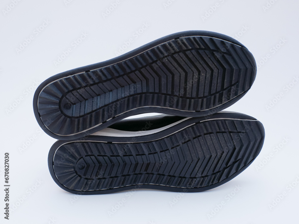 the bottom surface of a pair of black shoes. black rubber shoe soles of ...