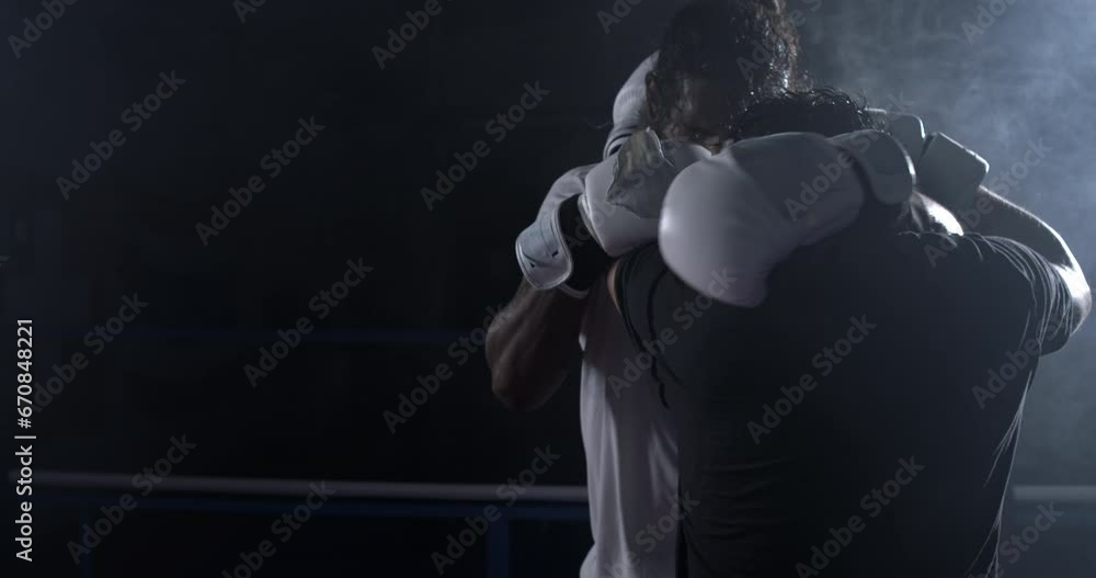 Two boxing fighters clinching each other prevent opponent from punching ...