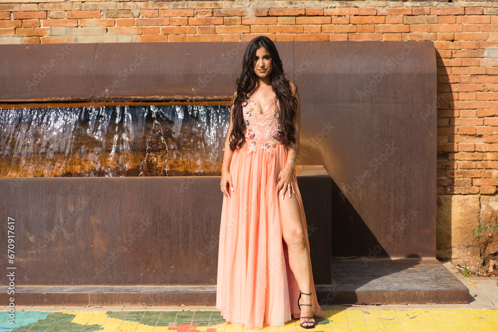 Beautiful Spanish woman with long curly hair poses as a model dressed ...