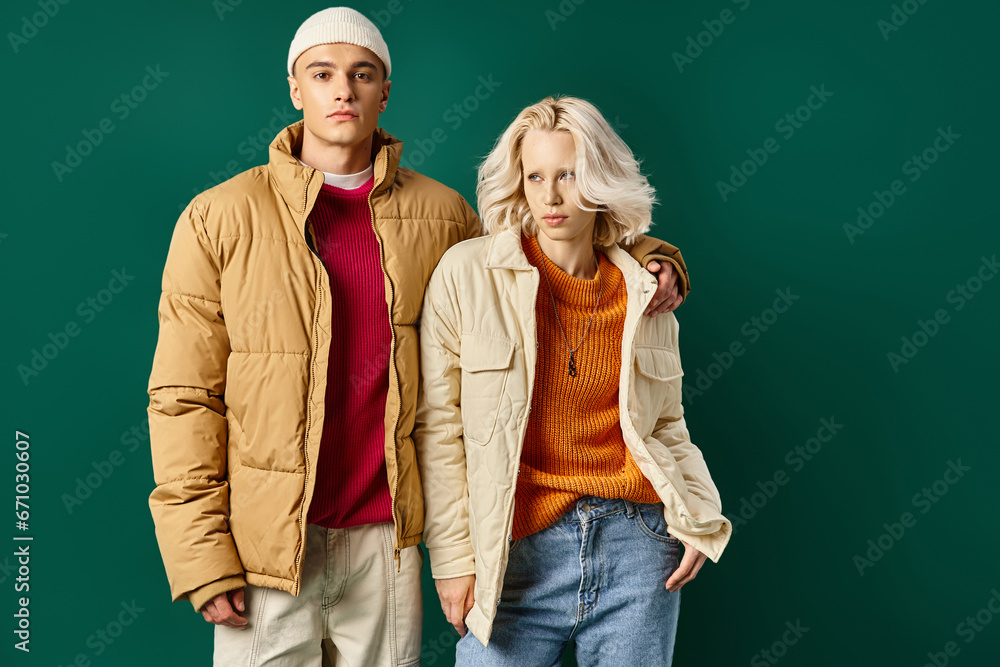 stylish man in winter puffer jacket hugging woman and posing together ...
