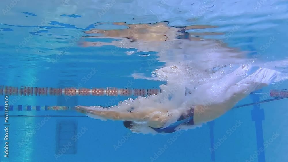 Woman athlete swims underwater in the pool. Slow motion of a female ...