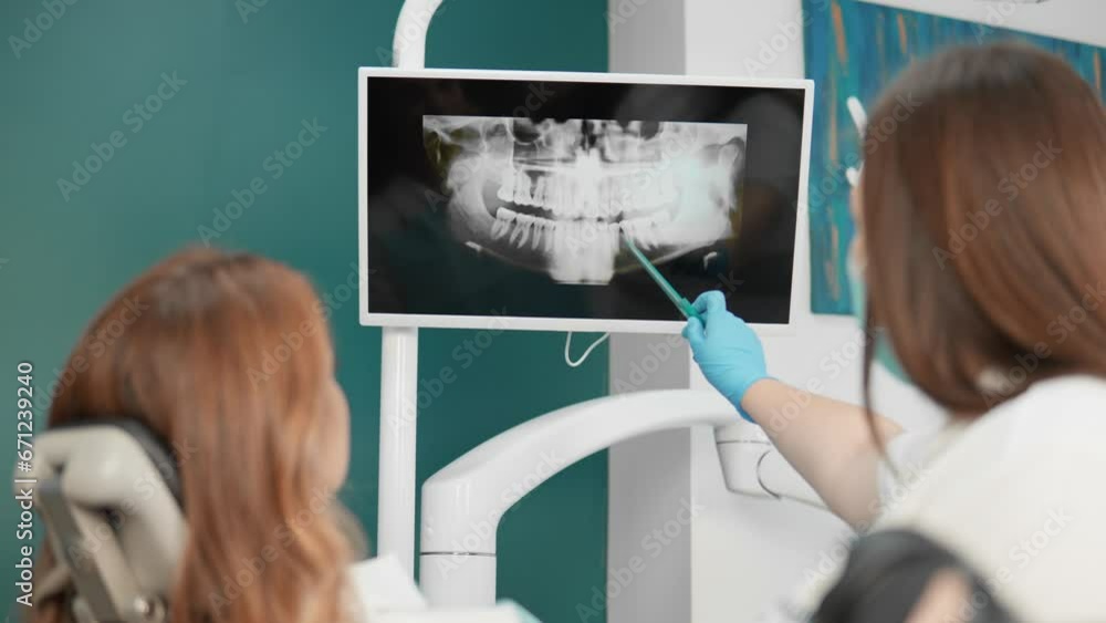 The dentist shows the woman X-rays of her teeth for a detailed ...