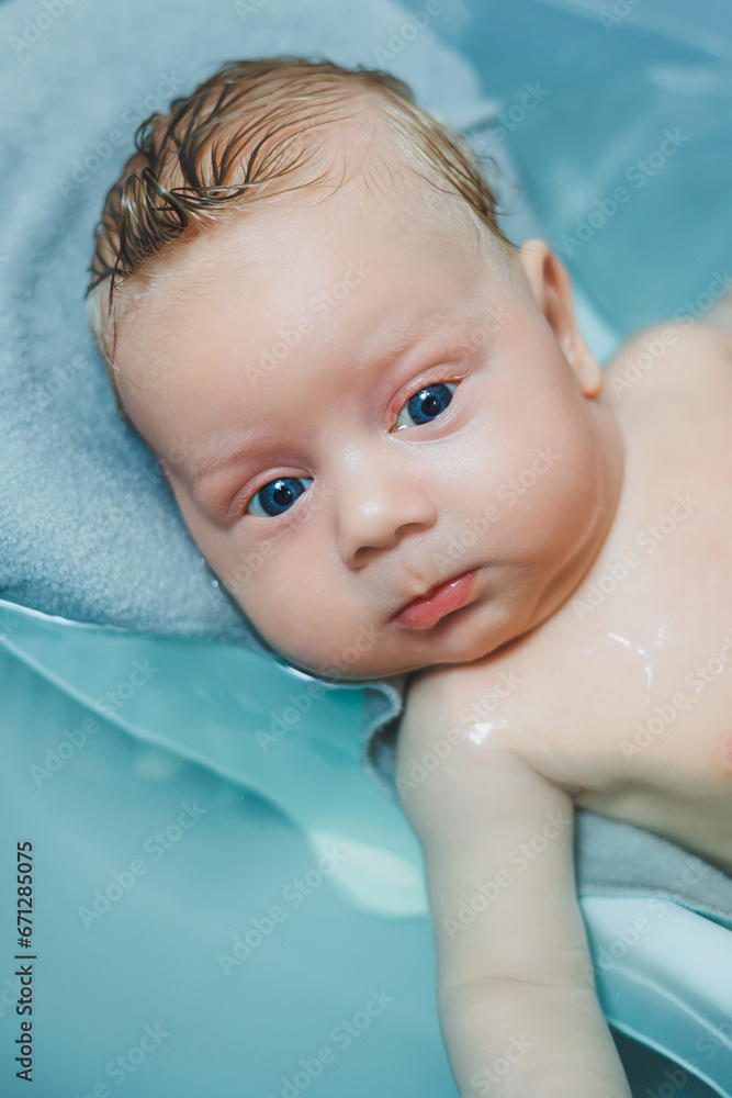 Bathing a baby in a baby bath. The first bath of a newborn baby. A baby ...