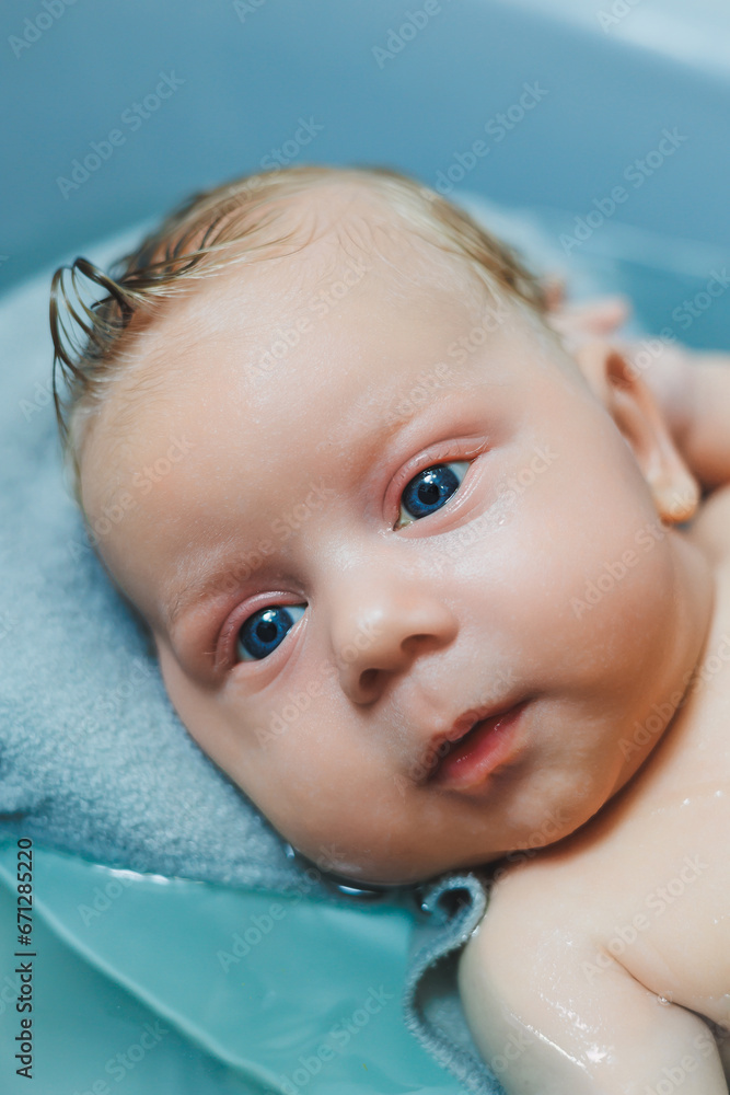 Bathing a baby in a baby bath. The first bath of a newborn baby. A baby ...