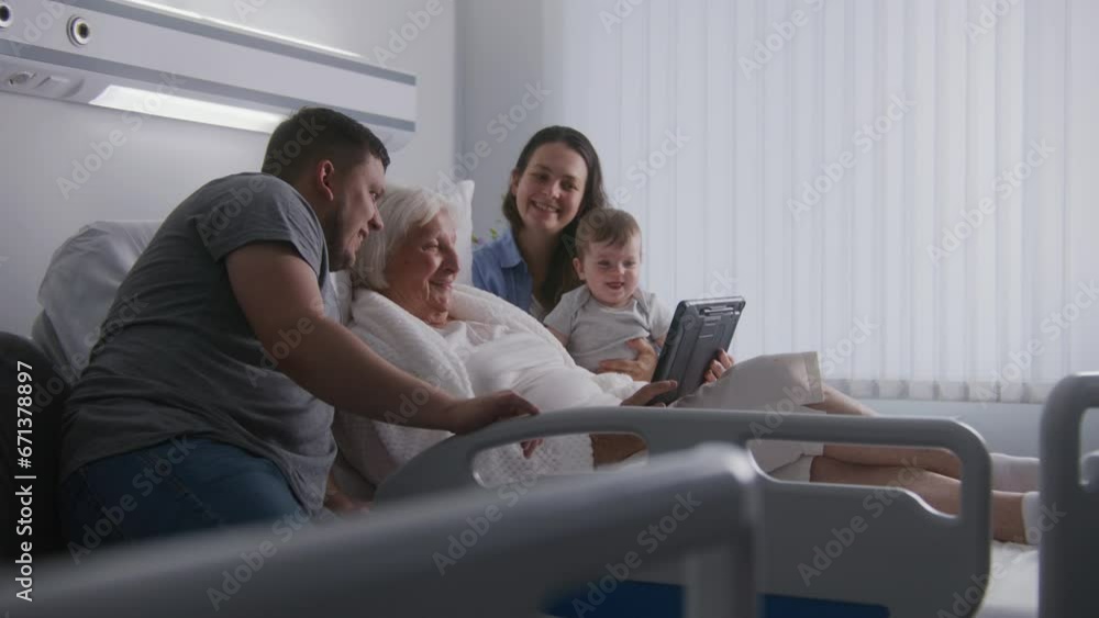 Hospital room. Senior woman lying in bed spends time with relatives ...