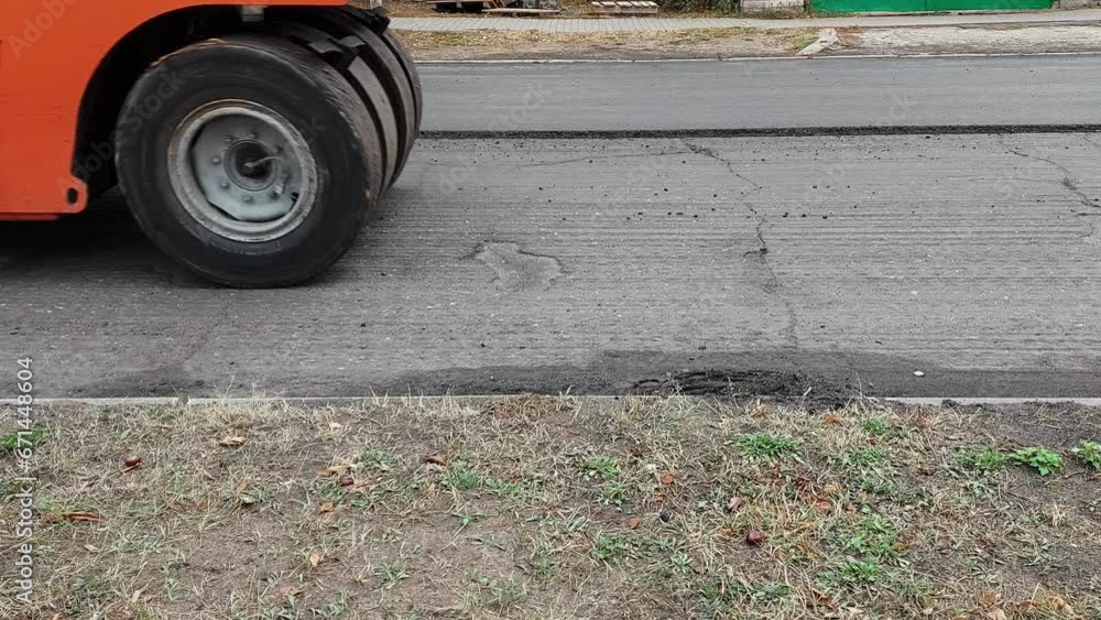 Pneumatic tyred roller moves on the cut road surface with the old ...