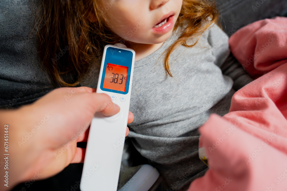Measuring body temperature of child. Digital thermometer showing high ...