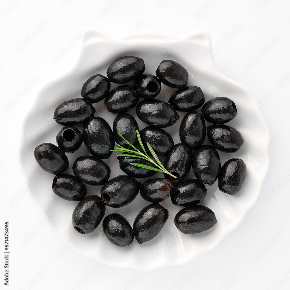 Delicious black olives in plate with olive tree sprig decoration ...