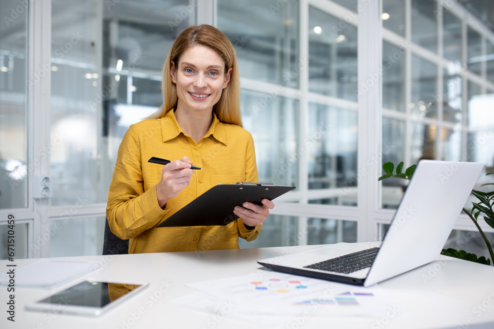 Portrait happy successful woman financier doing paperwork ...