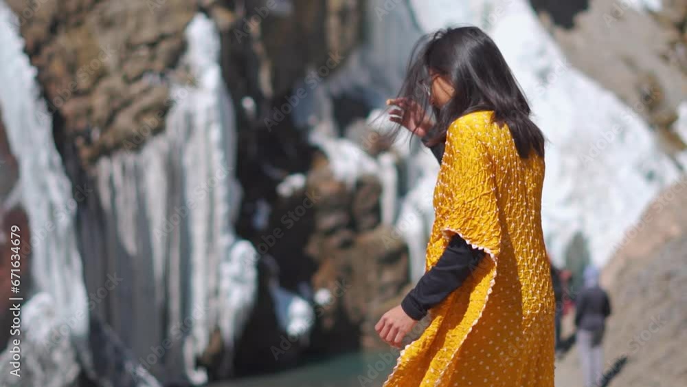 Beautiful Indian girl looking at frozen Lingti waterfall at Spiti ...