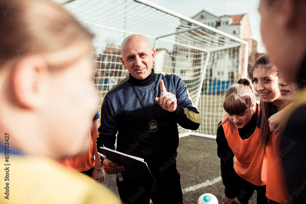 Dedicated coach offering guidance to his female soccer team during ...