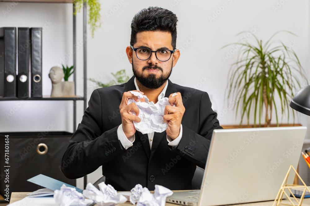 Angry furious Arab man working at office throwing crumpled paper ...