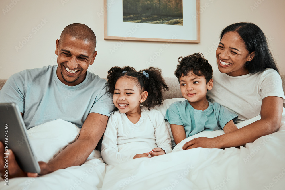 Parents watching a movie on a tablet with their kids in the bed to ...