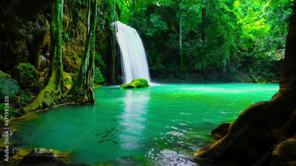 Waterfalls and fish swim in the emerald blue water in Erawan National ...