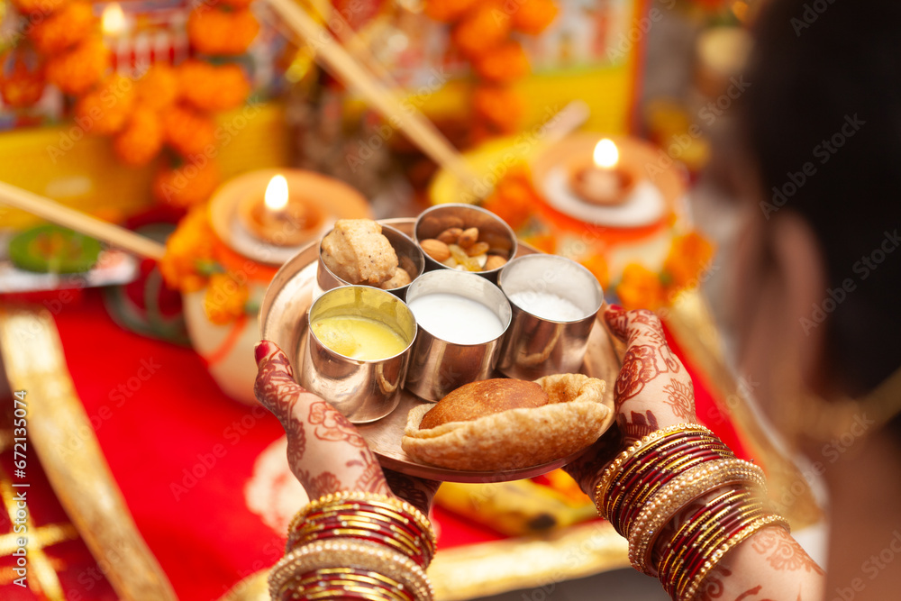 An Indian woman performing puja rituals with a plate of 'Prasadam ...