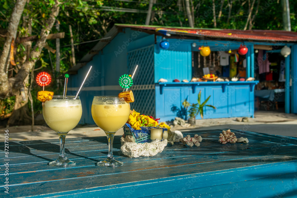 Cocktails on a table in a colorful beach bar in La Digue island ...