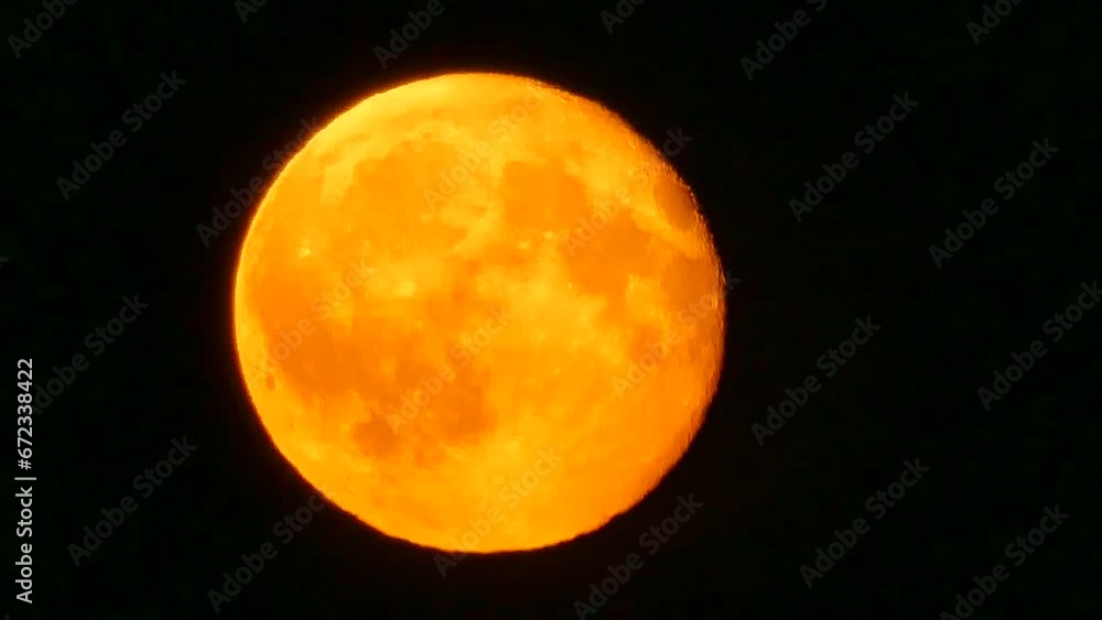 Dark night sky and orange and yellow rising moon disc with Atmospheric ...