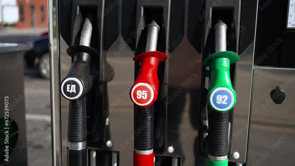 A close-up of gasoline fuel dispensers with a fuel pump nozzle at a gas ...