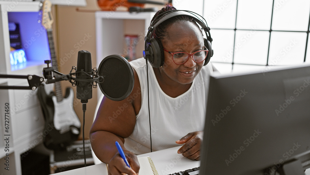 Smiling african american woman, a confident musician, composing a ...