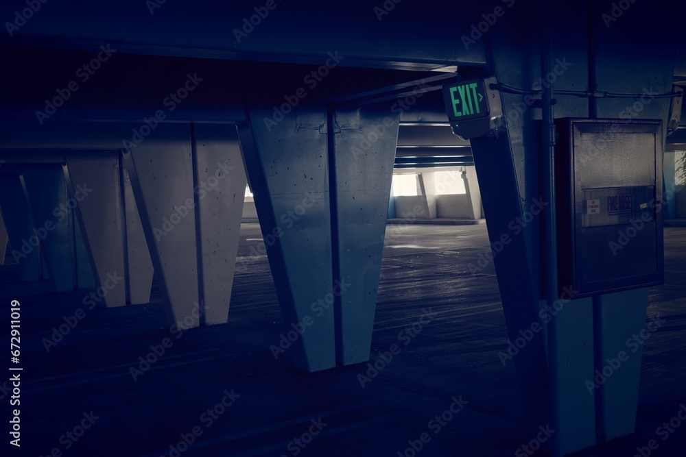 Dark parking garage, featuring a lit exit sign on the column Stock ...