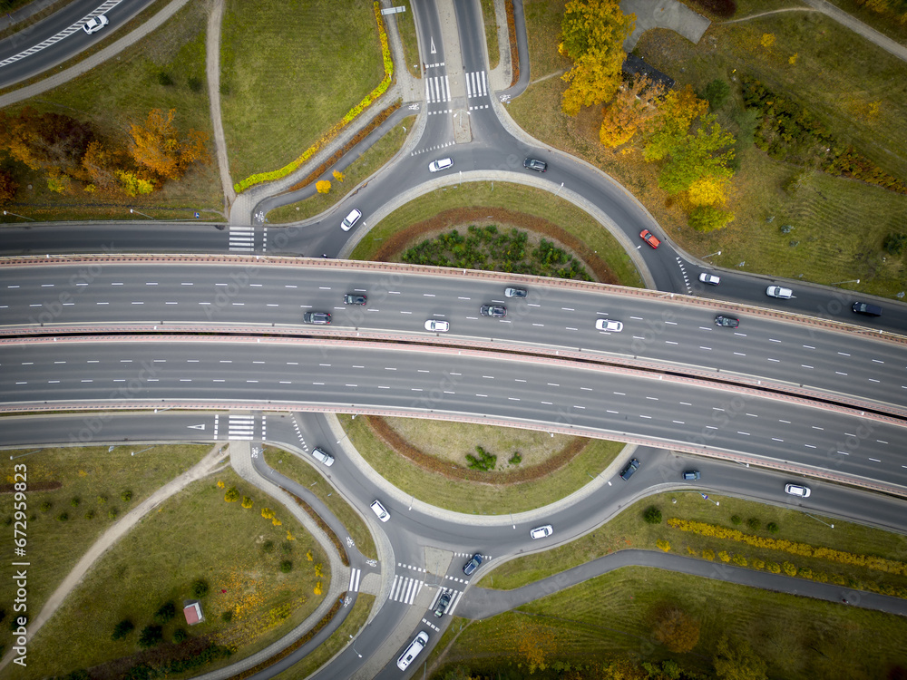 traffic on a expressway running over roundabout, top-down drone view ...