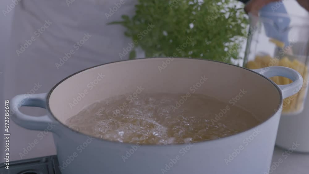 Vidéo Stock Throwing homemade pasta into a pot of hot boiling water on ...