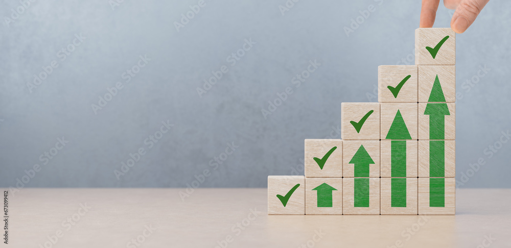 Wooden blocks checklist and green check mark icons with hand on table ...
