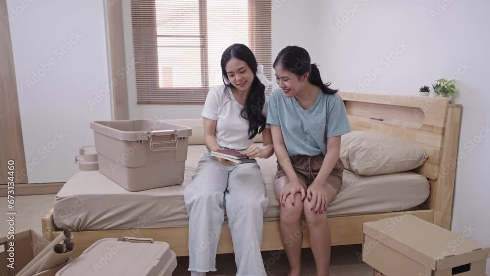 Two young Asian female friends are diligently organizing their ...