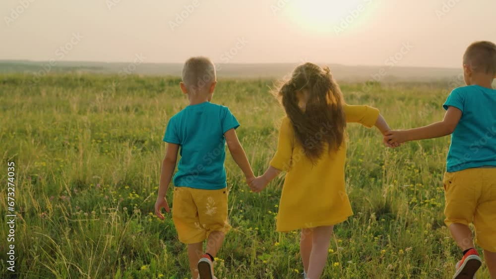 Happy childhood, nature. Happy kids play go across flower meadow. Boy ...