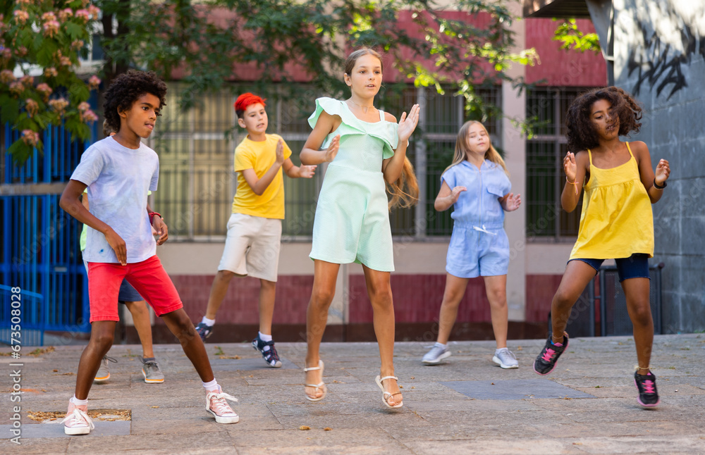 Group of multiracial positive kids jumping while performing street ...