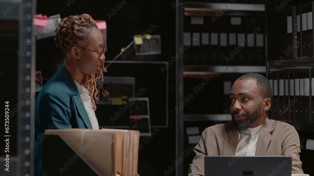Two investigators studying forensic evidence on wall map, discussing ...