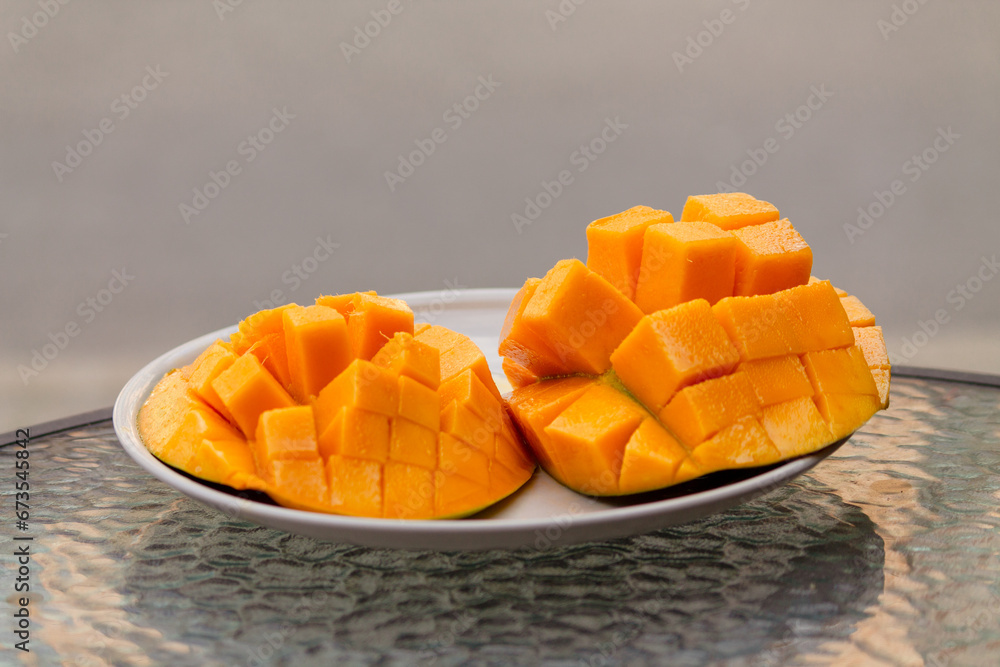 Mango. Close-up of a fresh ripe tropical mango fruit cut into special ...