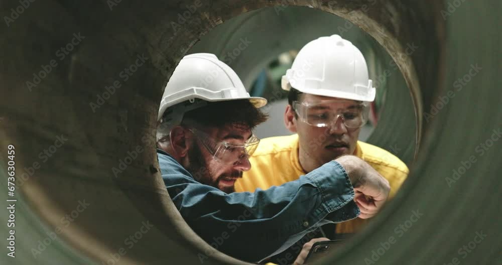 Team of engineer workers wearing safety helmets Use tablets to inspect ...