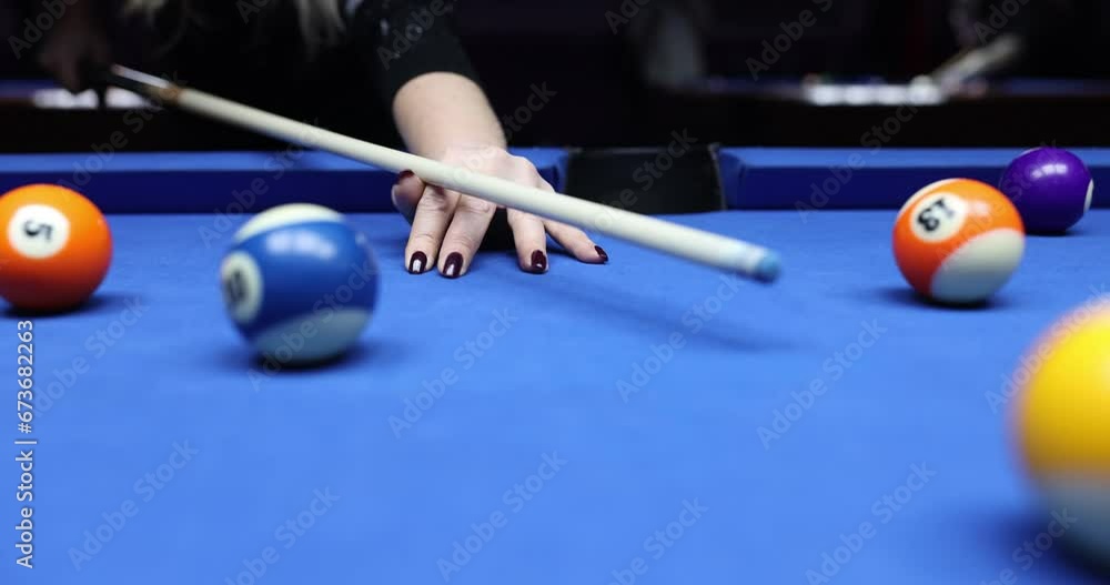 Female player shots ball to push goal into pocket on billiard table ...