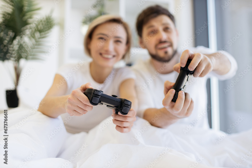 Focus on joysticks on hands of concentrated caucasian couple playing ...