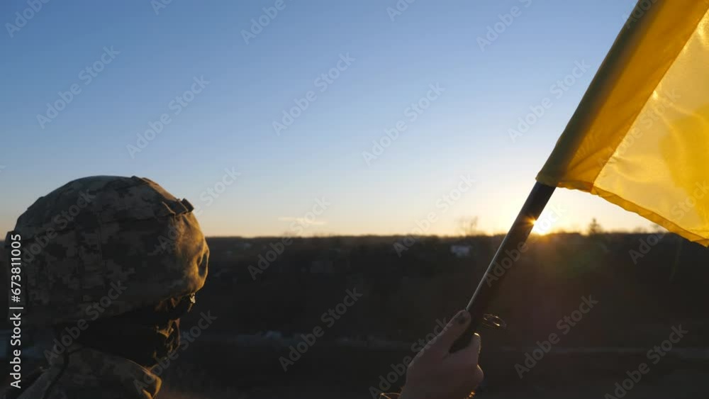 Dolly shot of male ukrainian army soldier lifting national banner in ...