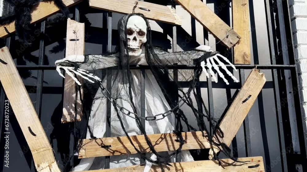 Grim reaper skeleton swings in a wind on a street. Still life of ...