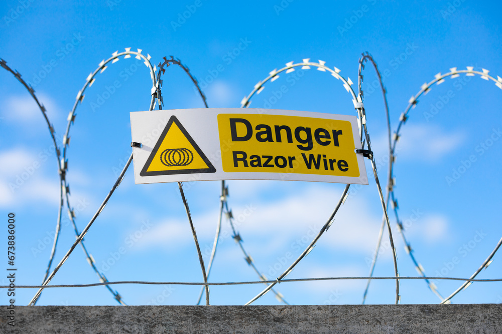 Razor wire on top of the wall. Border. Perimeter security. Stock Photo ...