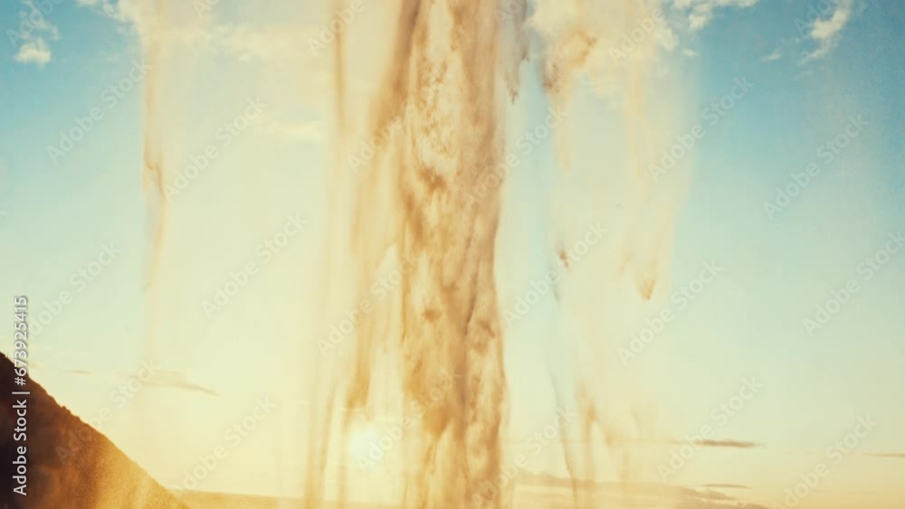 Spectacular waterfall at sunset. Huge flow of water seen from behind ...