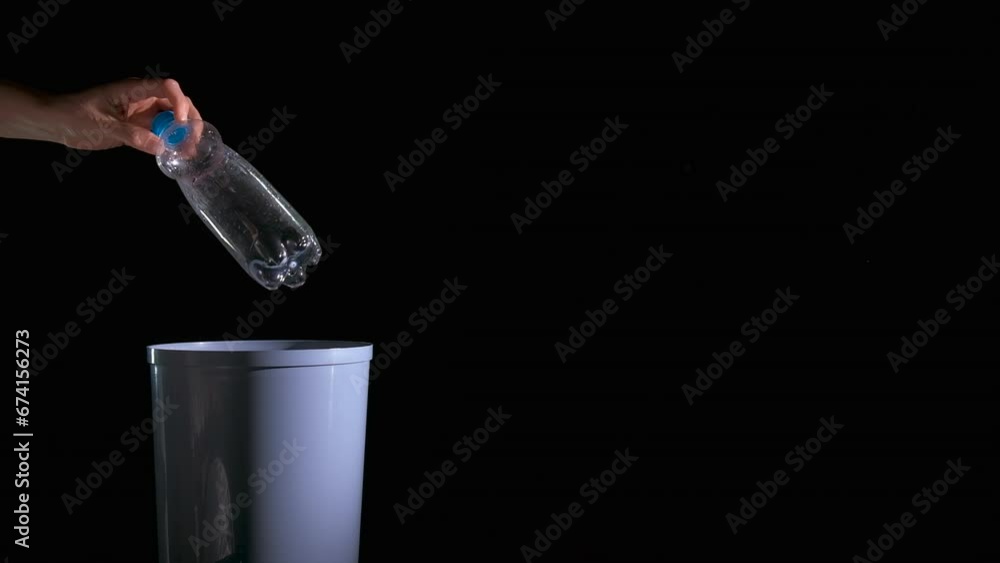 Arm with bottle by bin. A view of person arm throwing the plastic ...