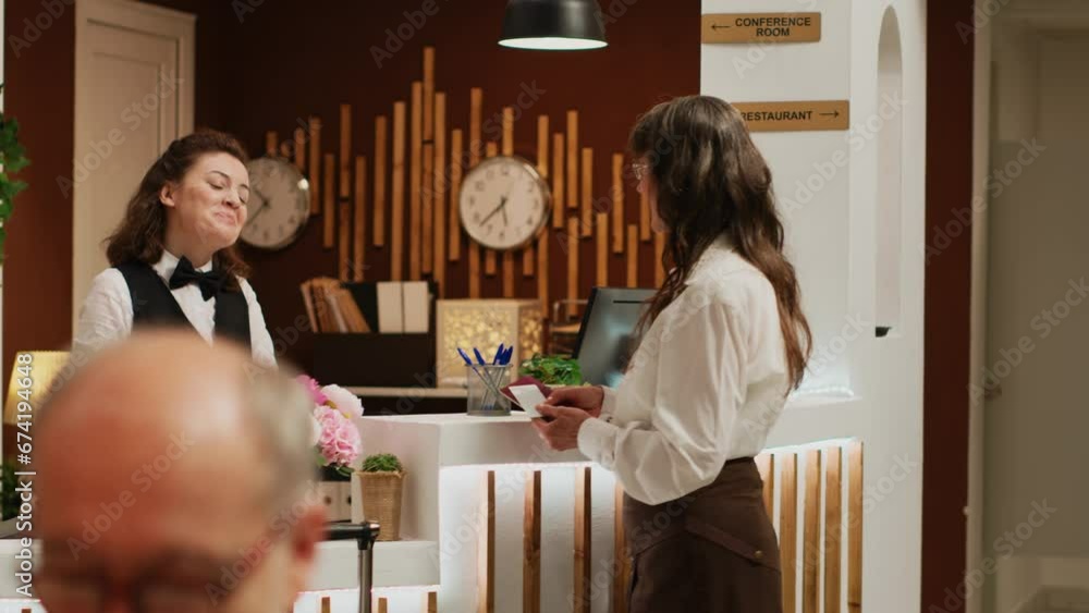 Employee checking passport info to fill in visitor forms at luxurious hotel, receptionist ...