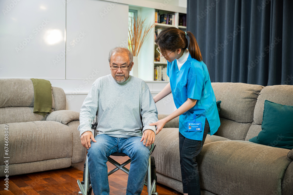 Asian nurse assisting helping senior man patient get up from wheelchair ...
